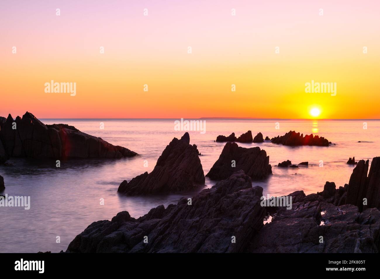 Beautiful calm sea and sunset scenery on the ocean as light reflects on ...
