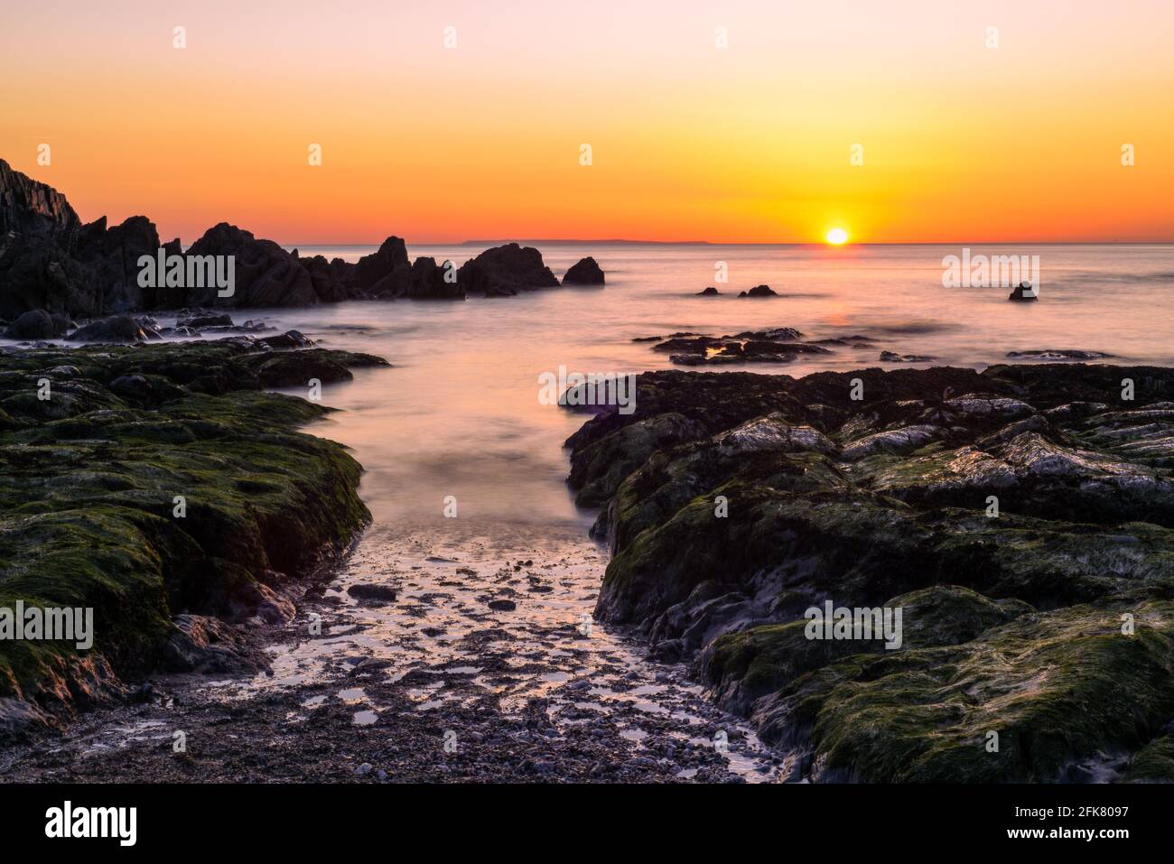 Beautiful calm sea and sunset scenery on the ocean as light reflects on ...
