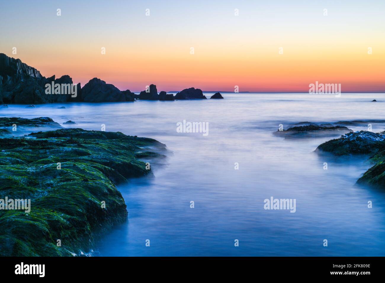 Beautiful calm sea and sunset scenery on the ocean as light reflects on ...