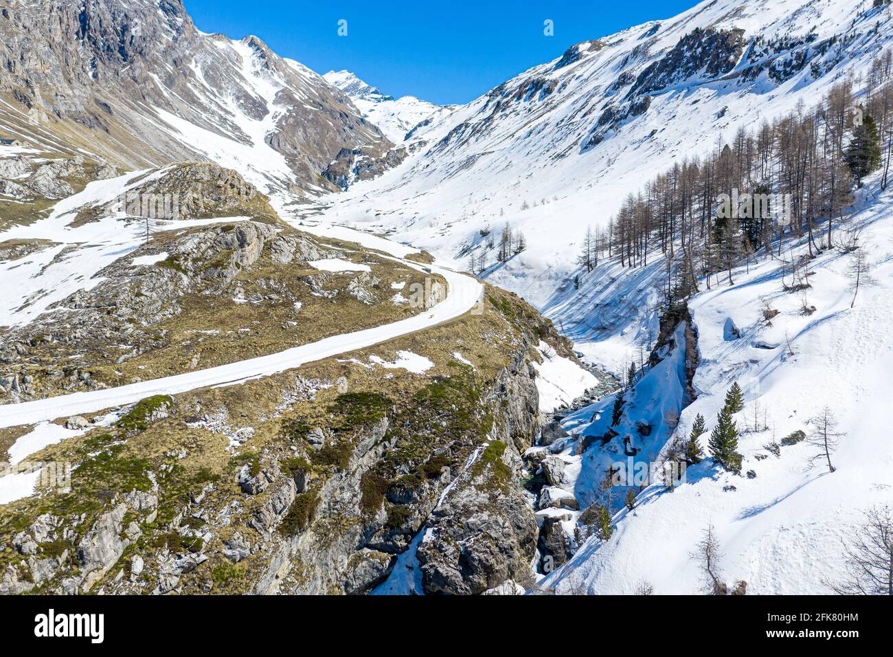 Snow covered path leading into the alpine mountains Stock Photo - Alamy