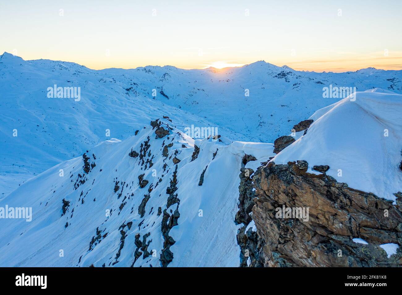 Sun rising behind a huge snow covered Mountain Stock Photo - Alamy