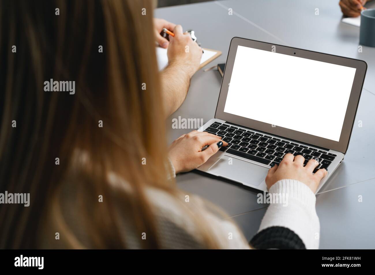 Back view of unrecognizable woman typing on laptop Stock Photo - Alamy