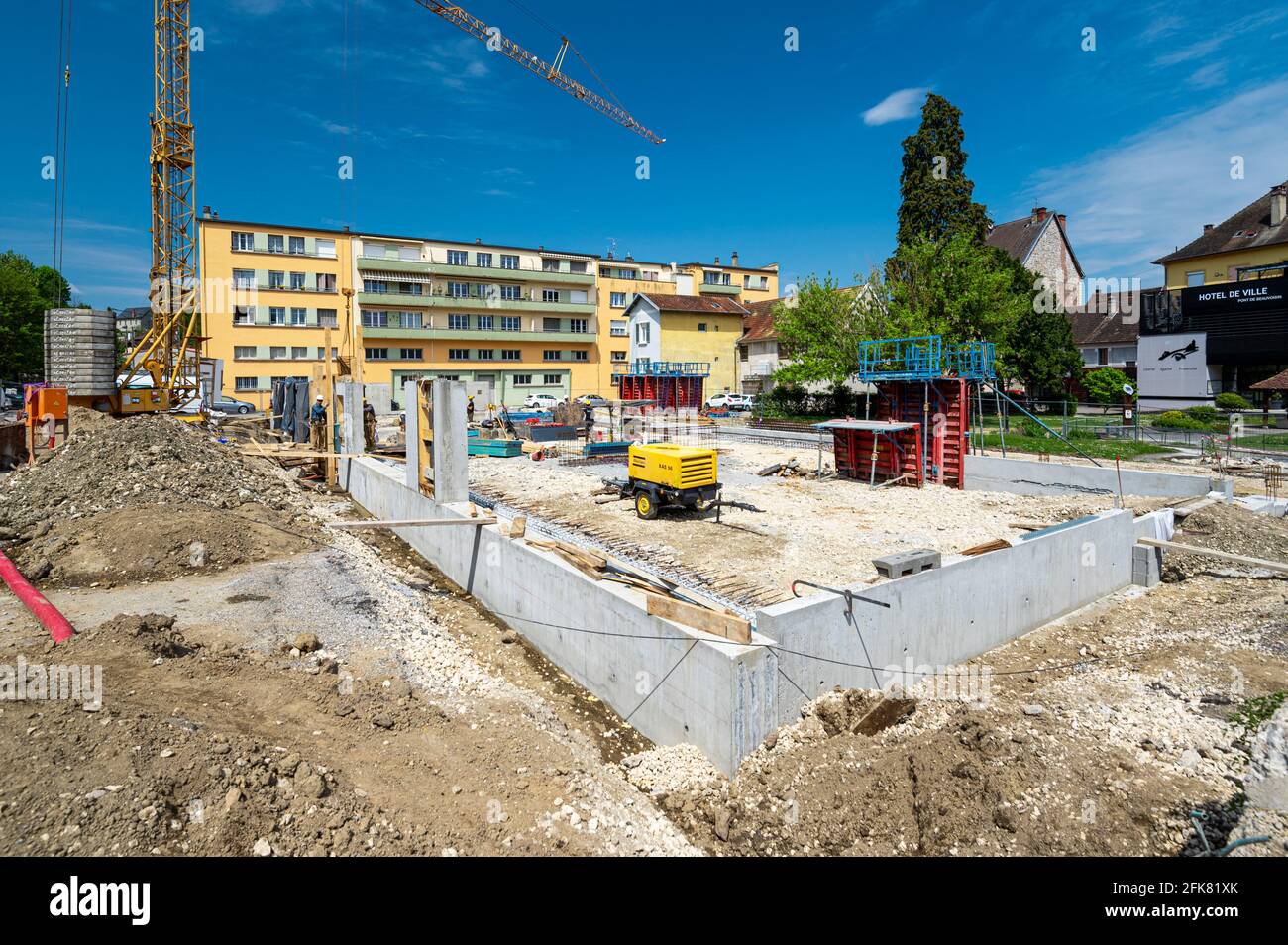 Low level, angle shot of crane working at a construction site in it's ...