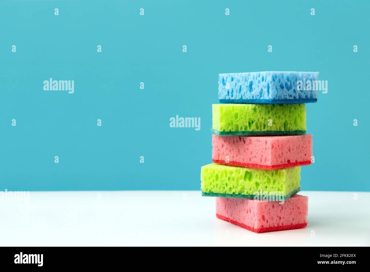 Stack of kitchen cleaning sponges on blue background. Front view Stock ...