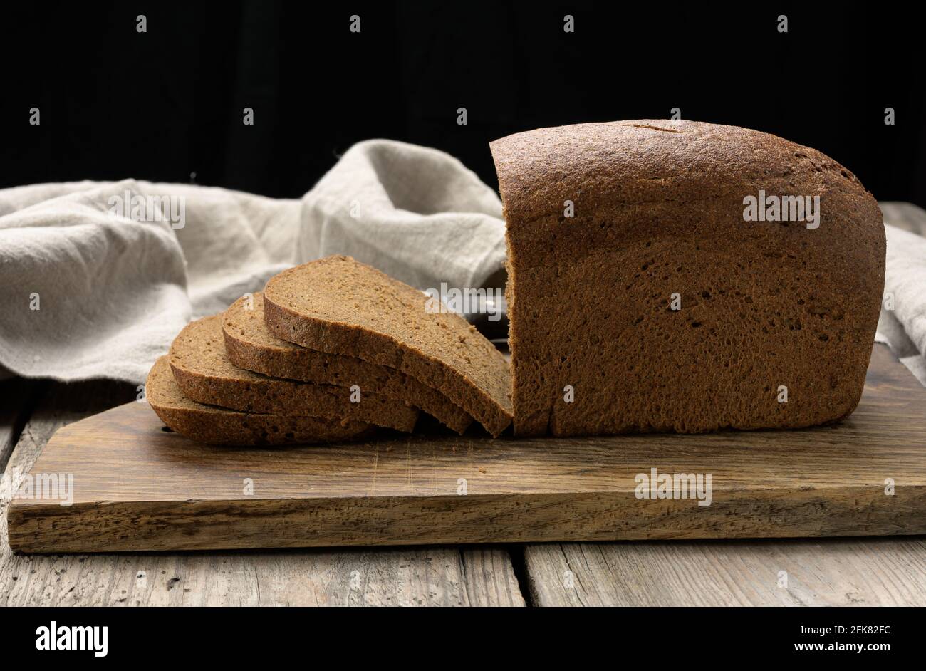 sliced baked rectangular rye flour bread on brown board, healthy food ...