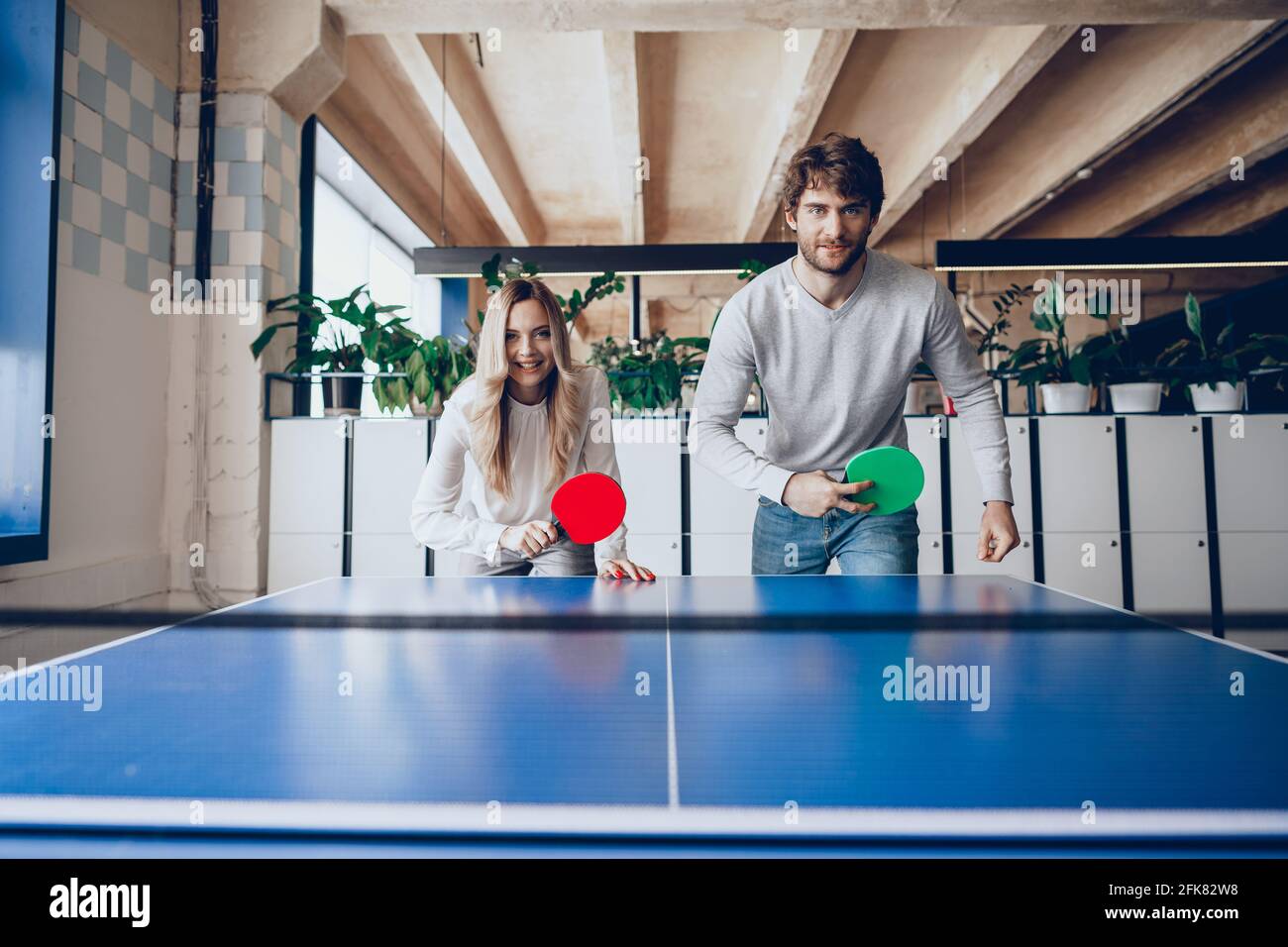 Young people, man and woman playing table tennis Stock Photo - Alamy