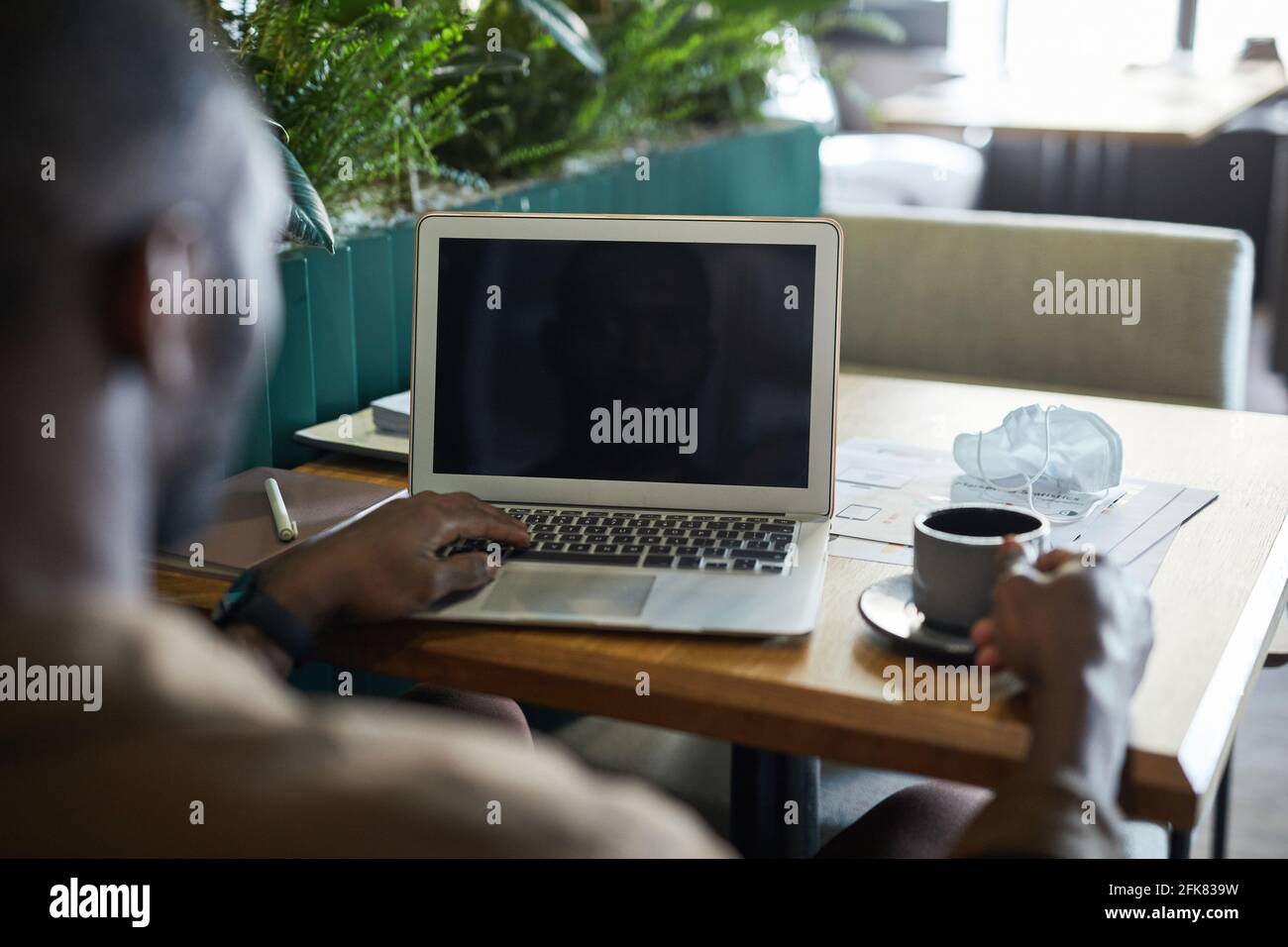Back view of black man sitting at table hi-res stock photography and ...