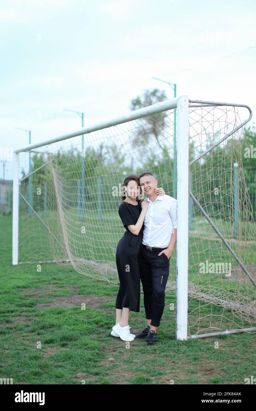 Young woman hugging man in football goal Stock Photo - Alamy