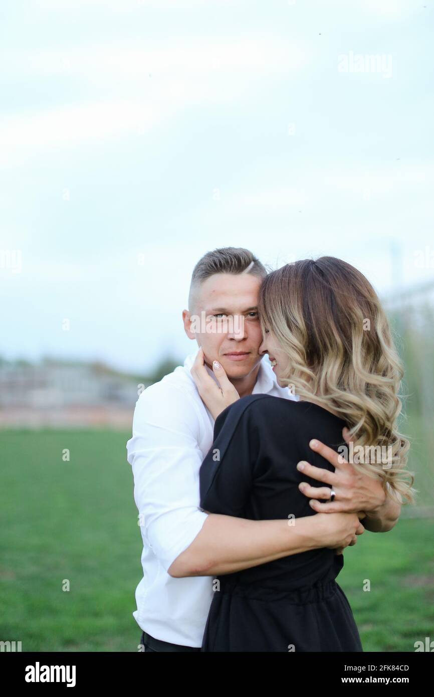 Portrait of european man hugging back view girl on football field Stock ...