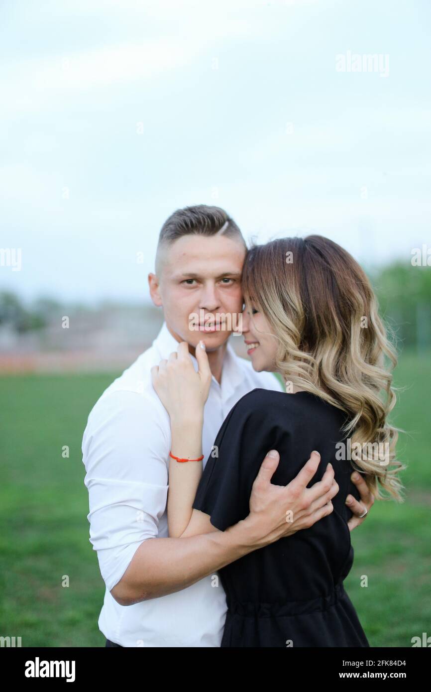 Portrait of boy hugging back view girl on football field Stock Photo ...