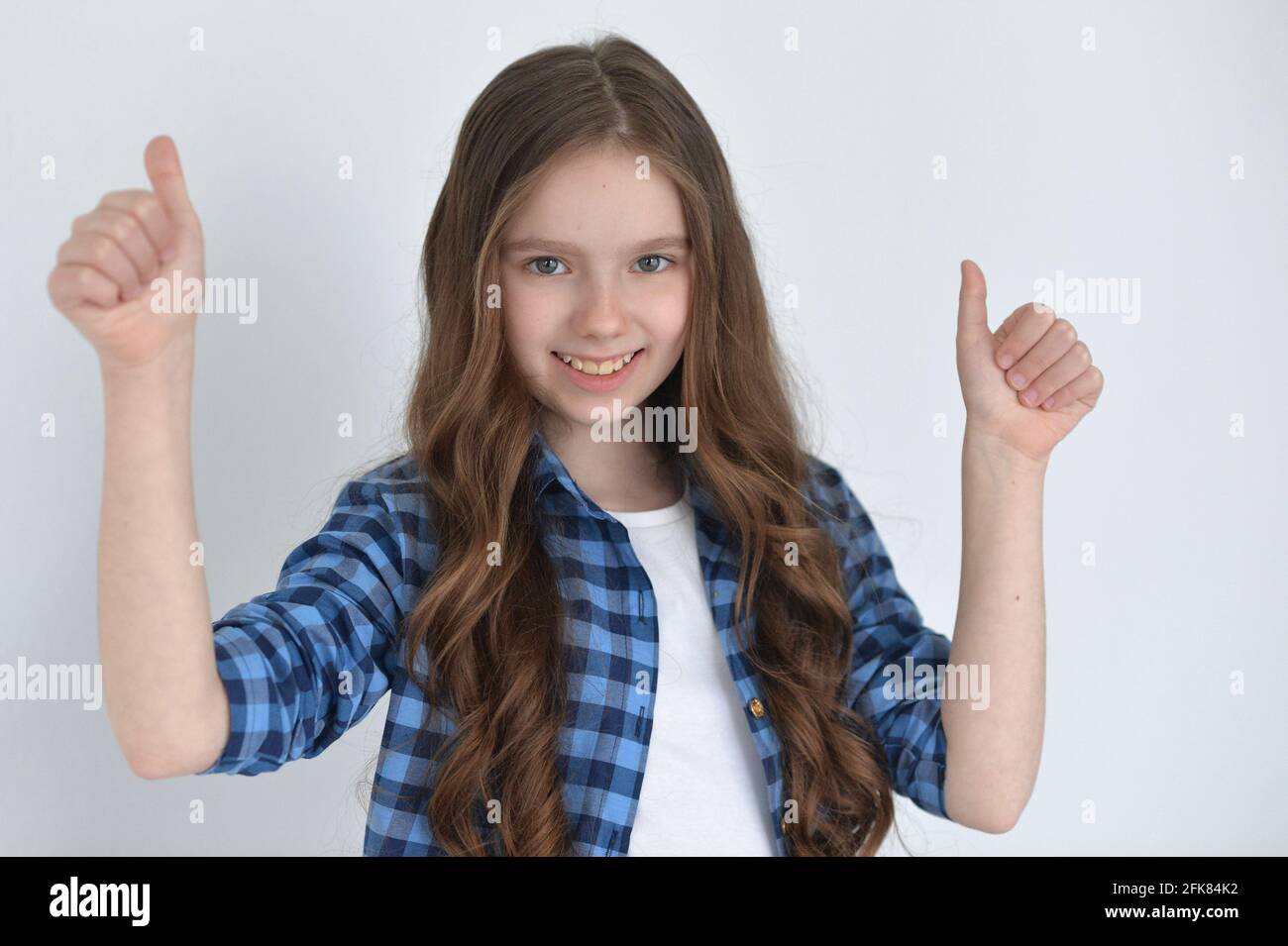 Cute girl with thumbs up posing isolated on white background Stock ...