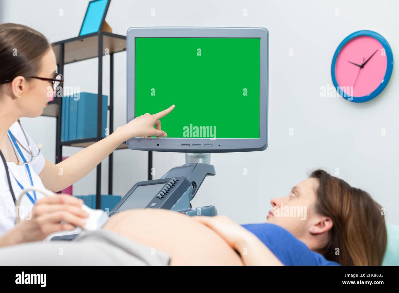 A doctor shows a pregnant patient her unborn baby on an ultrasound ...