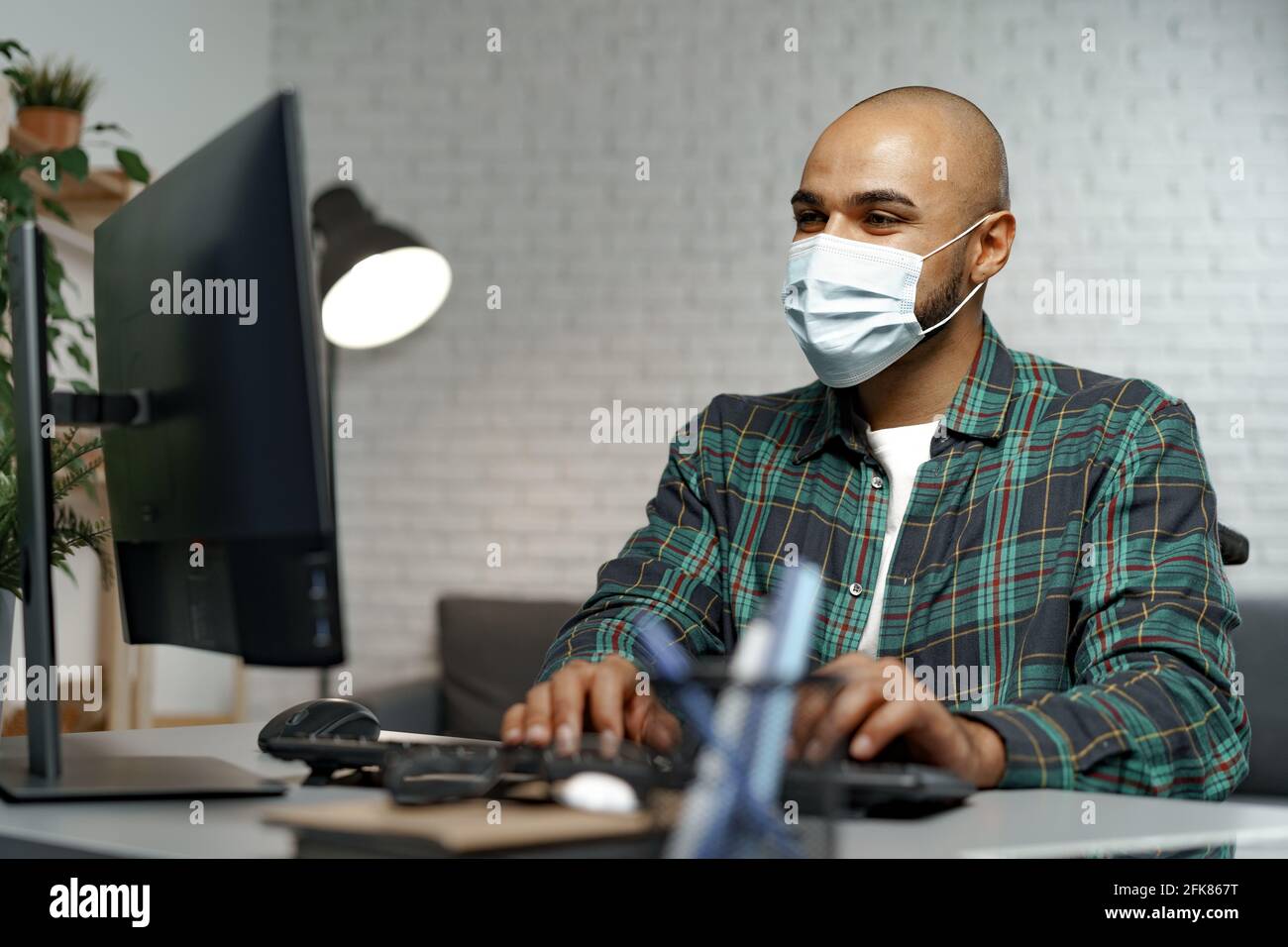 African american guy sitting at his working table and looking at ...