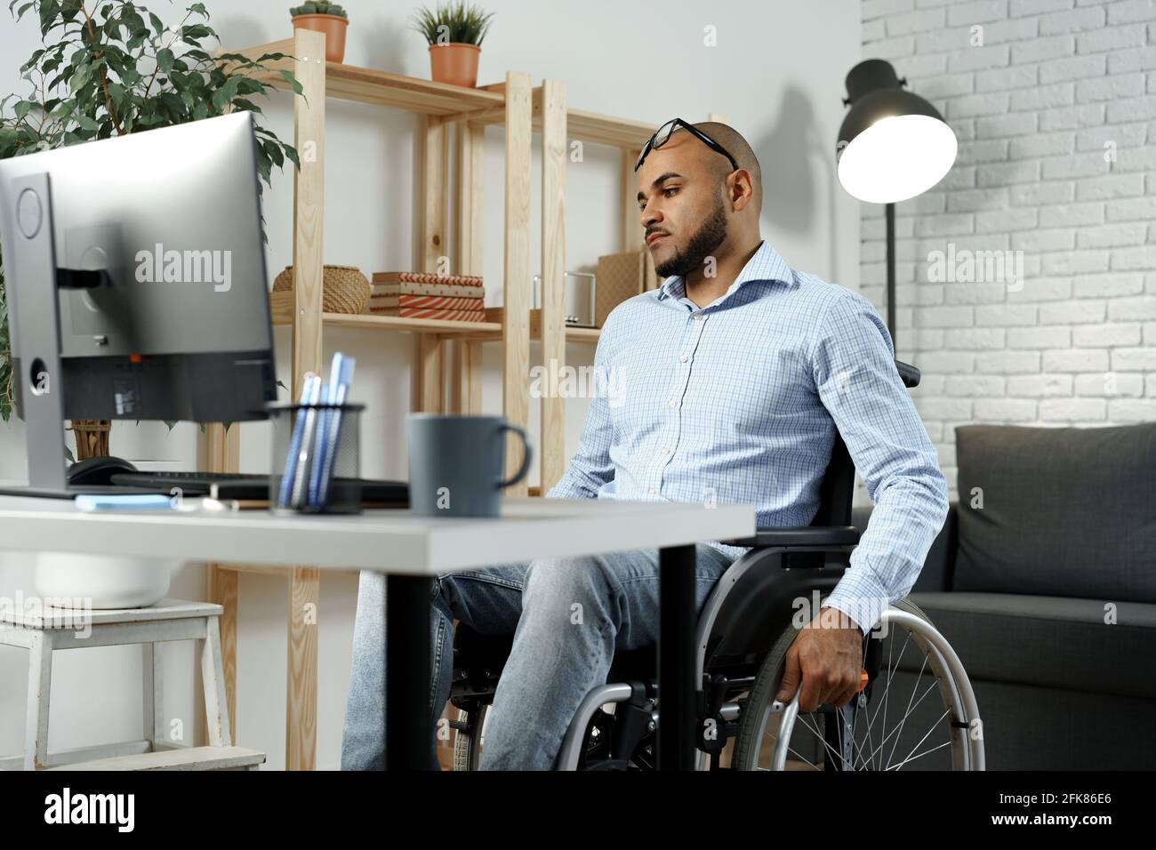 Disabled african american man sitting at the table and working on ...