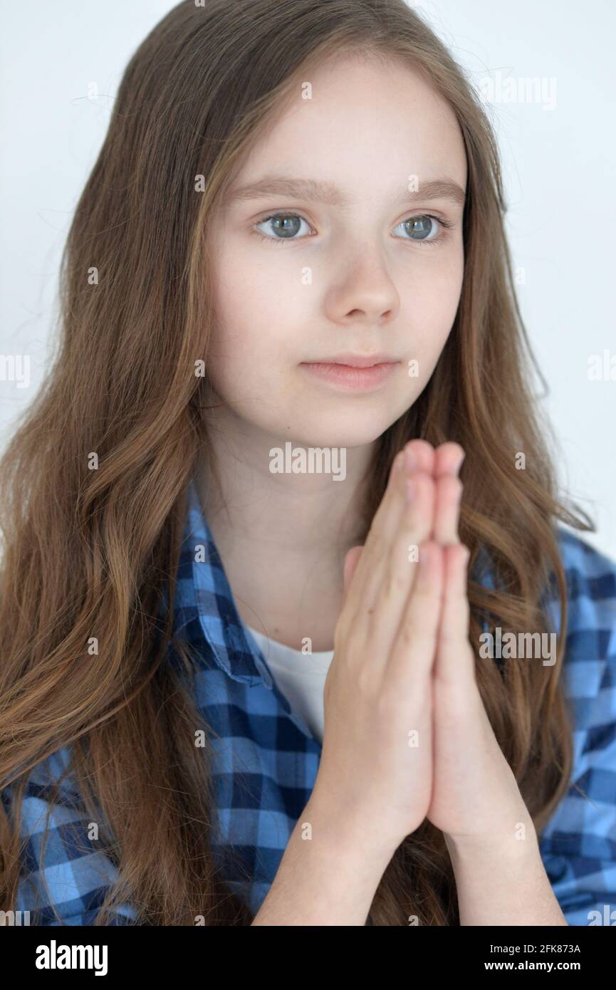 Cute girl praying isolated on white background Stock Photo - Alamy