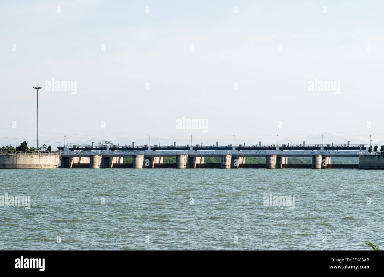 The many large gates of the service spillway on the reservoir dam, view ...