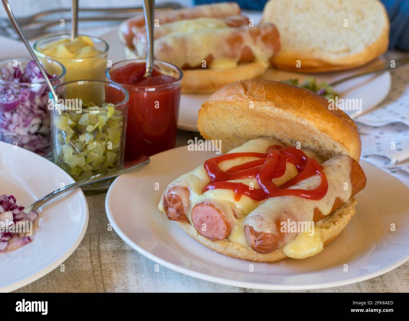 Tasty hot dog burger with melted cheese and ketchup served on a dinner ...