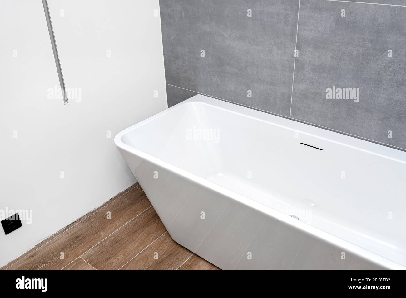 A modern, free-standing wall-mounted bathtub, without a tap, standing ...