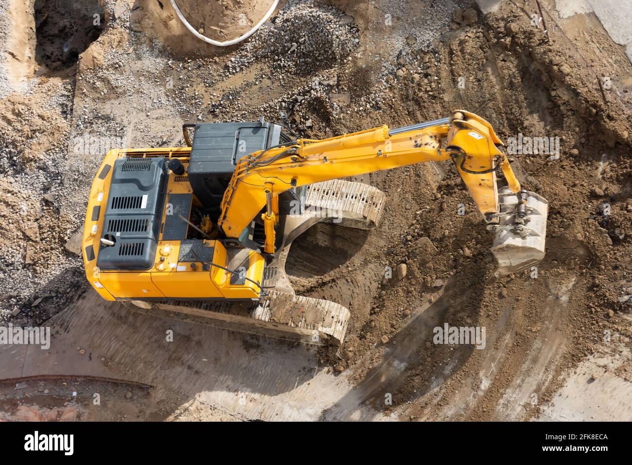 Excavator on the ground of a construction site with a raised bucket ...