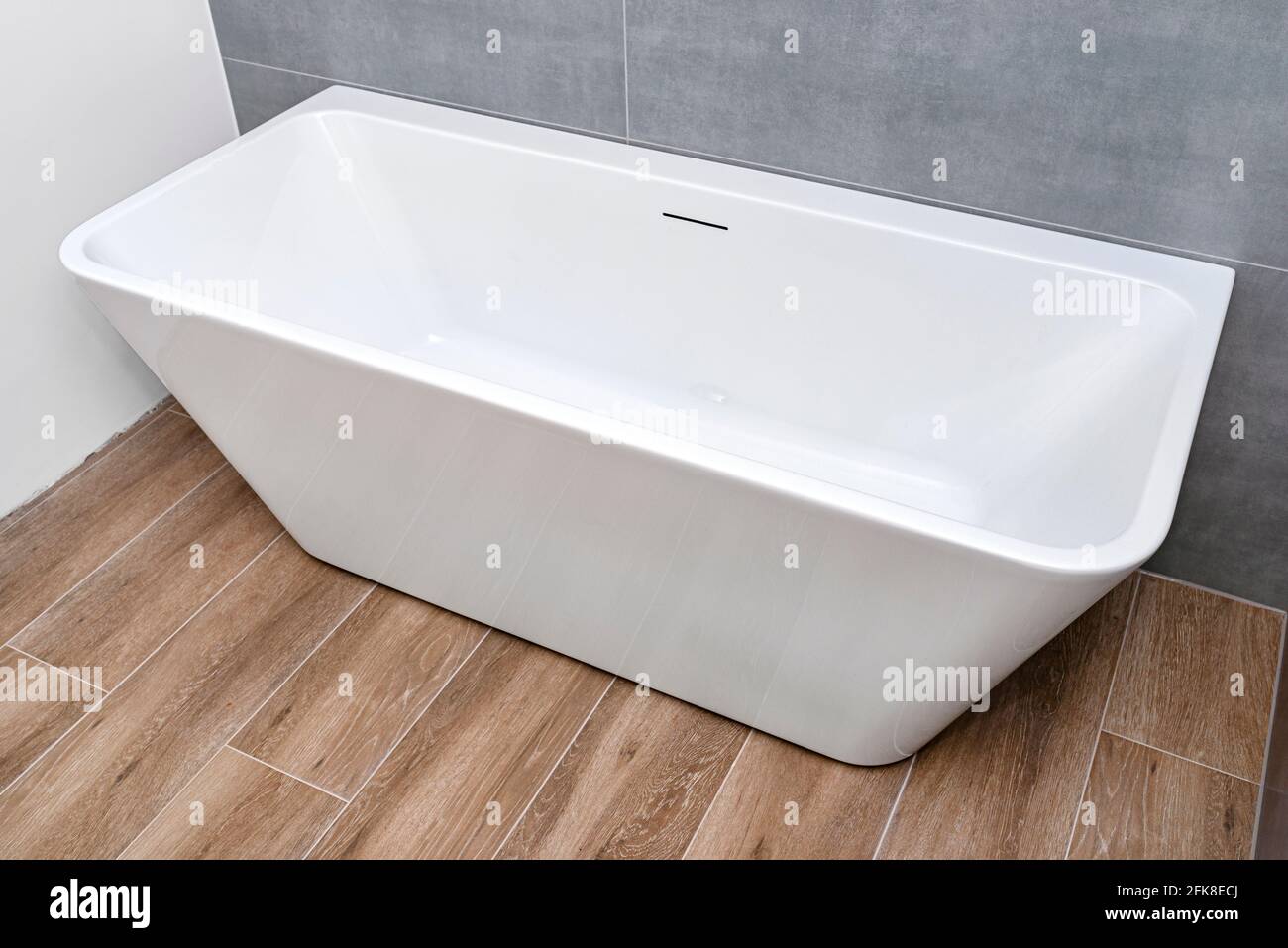 A modern, free-standing wall-mounted bathtub, without a tap, standing ...