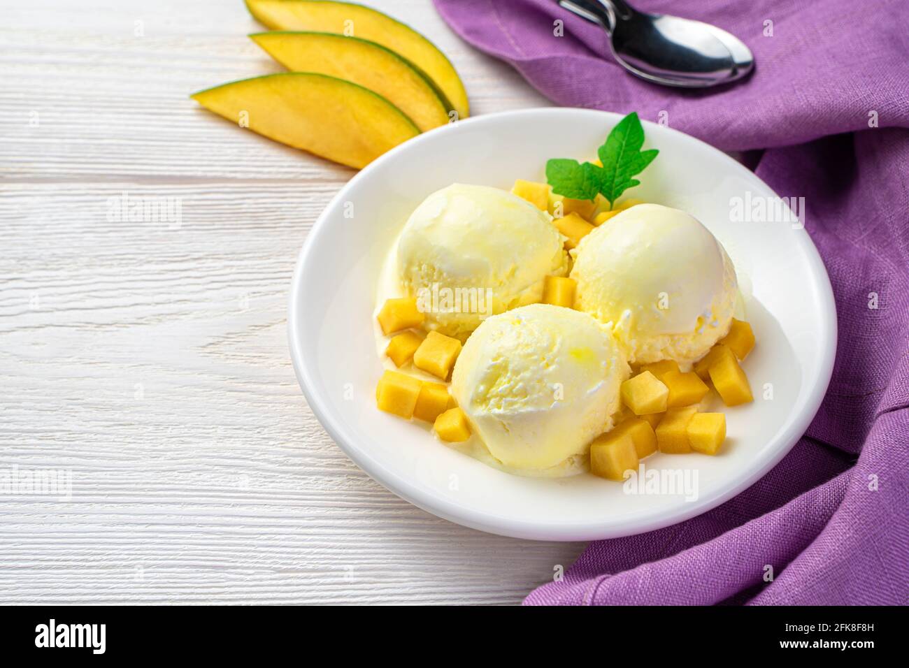 Mango ice cream balls and mango slices on a white background with space ...