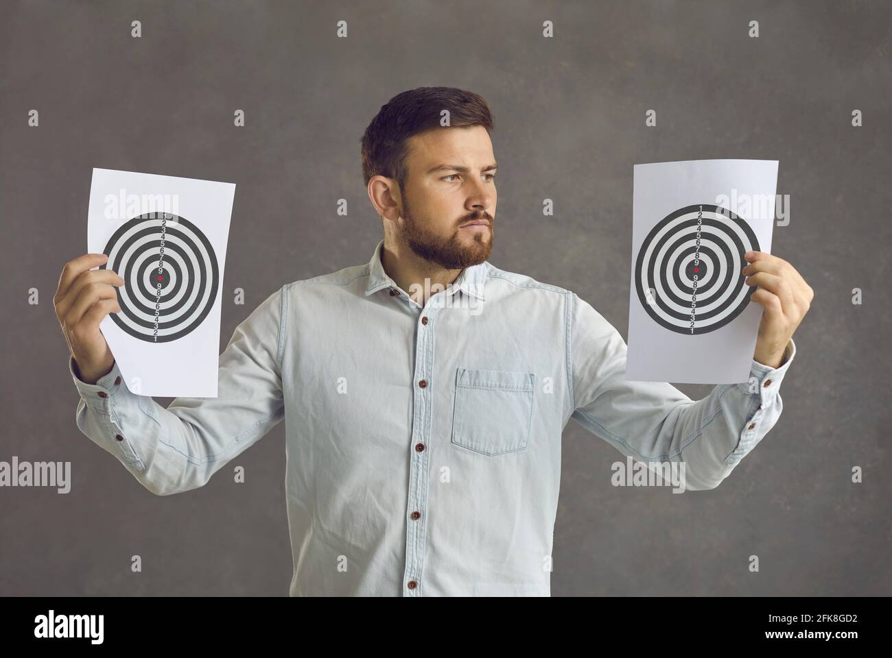 Man holding two targets as metaphor for setting goal and choice of ...