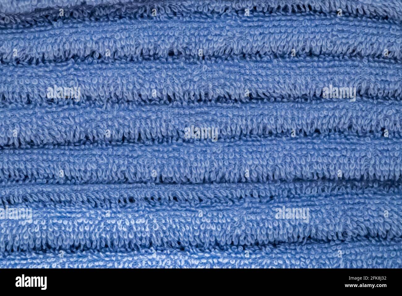 Texture of blue terry towel close-up. A stack of soft bath accessories ...
