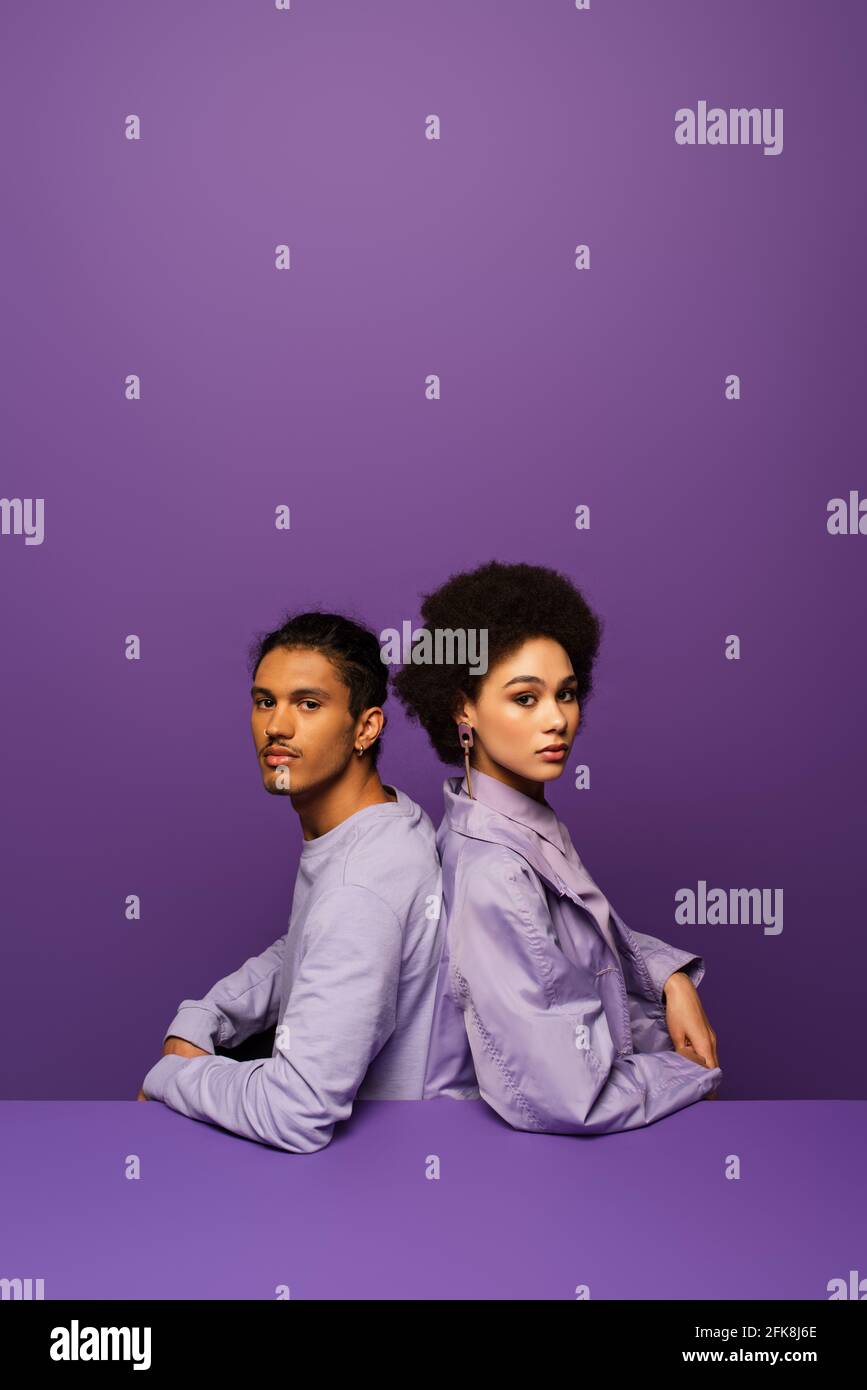 fashionable african american couple sitting back to back isolated on ...