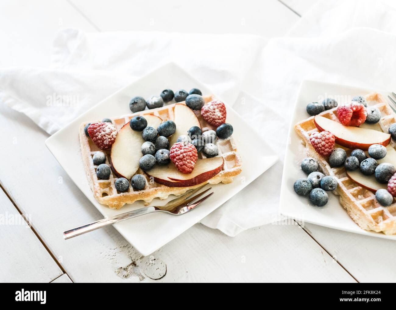 Breakfast waffles with fruit on a white plate. Clean and bright food ...