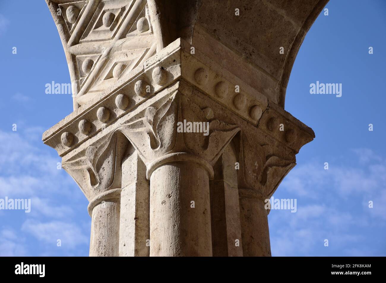 beige color carved classic stone column head. building detail. blue sky ...