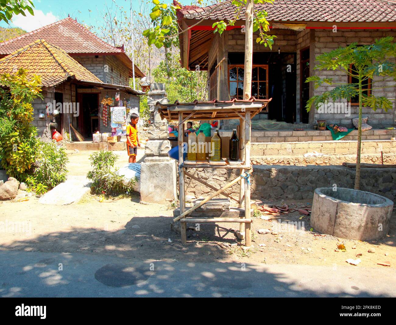 A poor, roadside stall features liters of gasoline for cars, scooters ...
