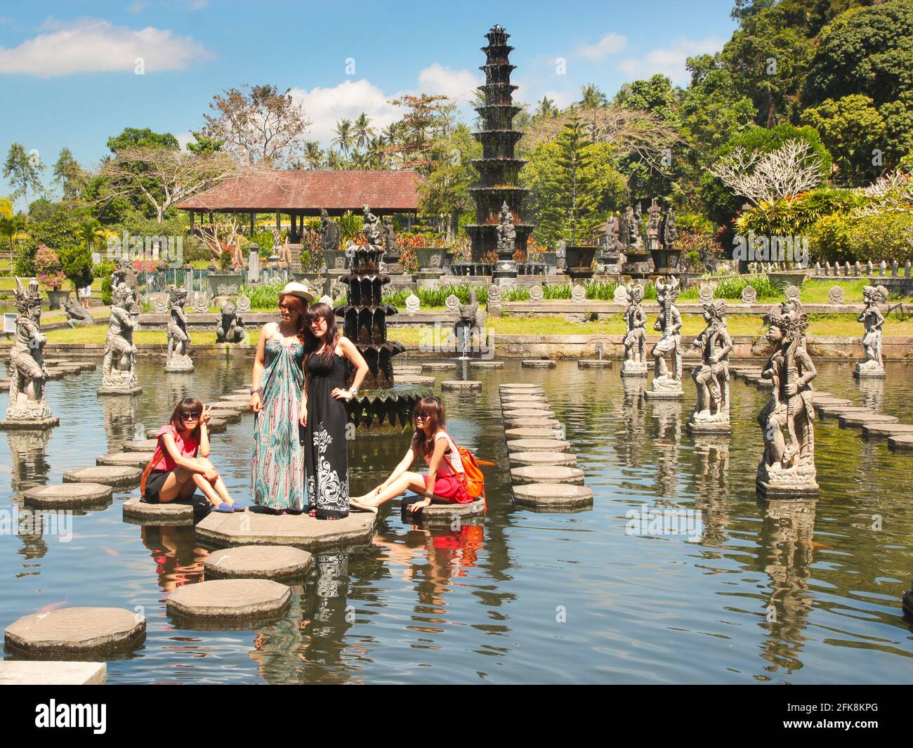 A group of tourists pose in the amazing water pond, full of exotic ...