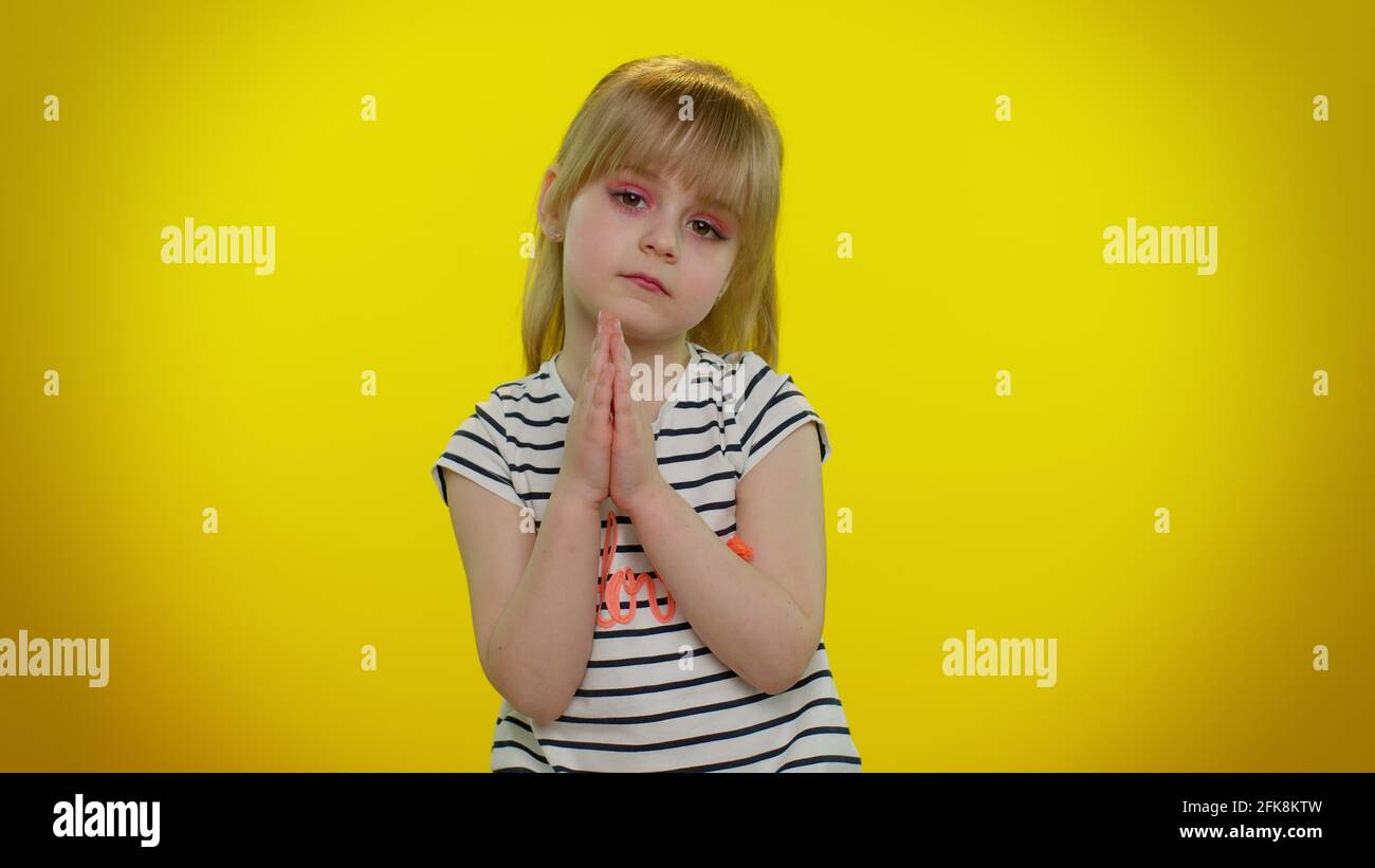 Child girl sincerely praying to God and looking up with pleading ...