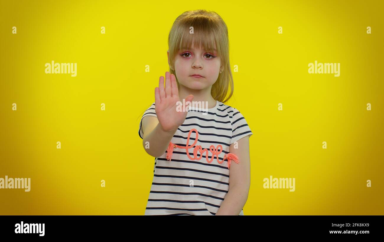 Little child kid girl say no hold palm folded crossed hands in stop ...