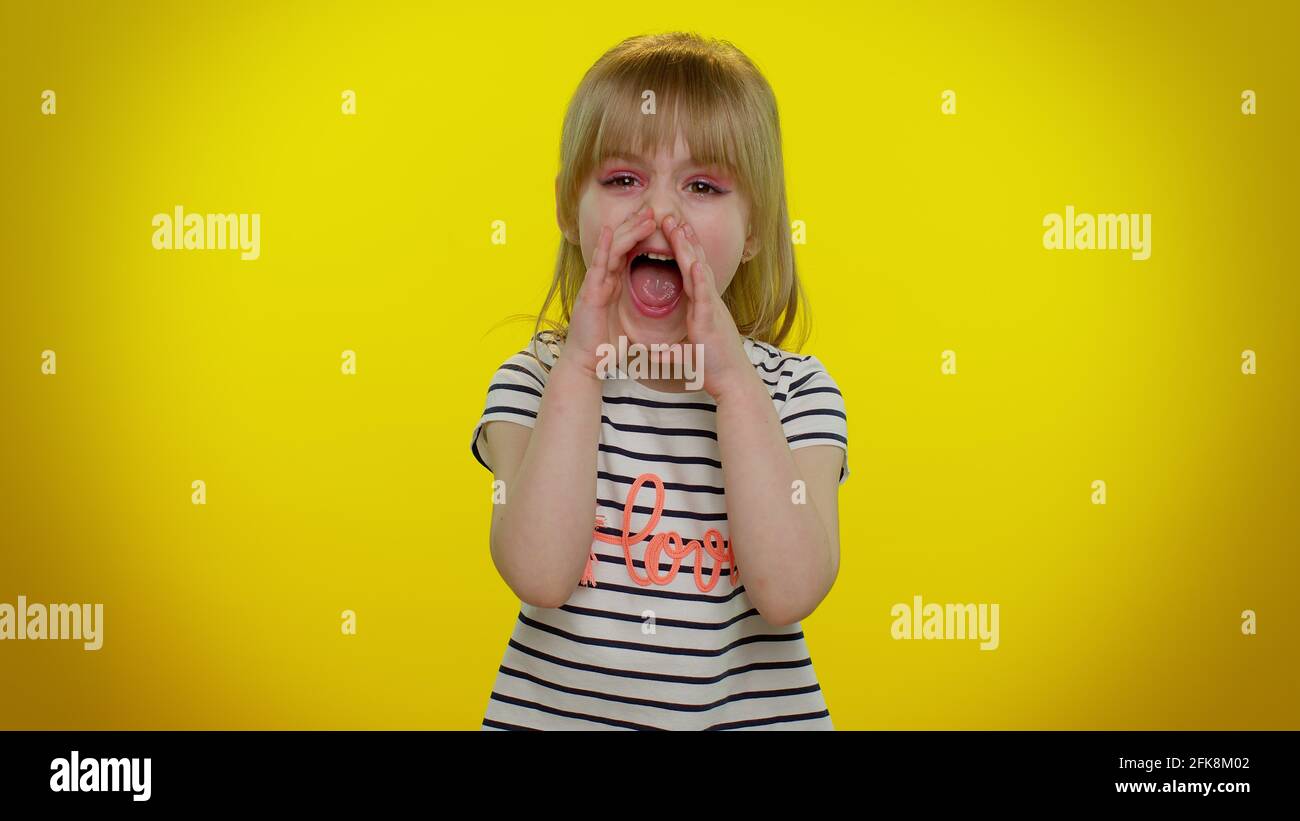 Little blonde teen kid child girl in t-shirt shouting hello, waving ...