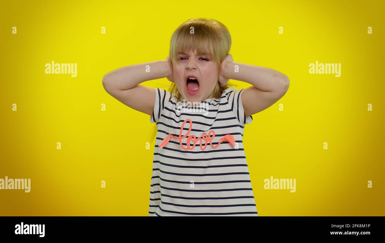 Frustrated annoyed irritated kid child girl covering ears and gesturing ...