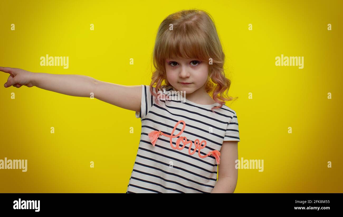 Serious child girl kid pointing finger away asking to leave her alone ...