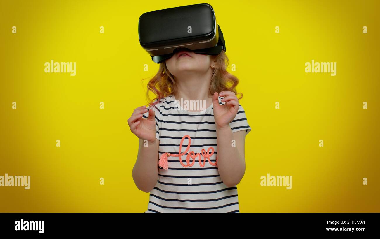 Little teen child kid girl using virtual reality VR app headset helmet ...