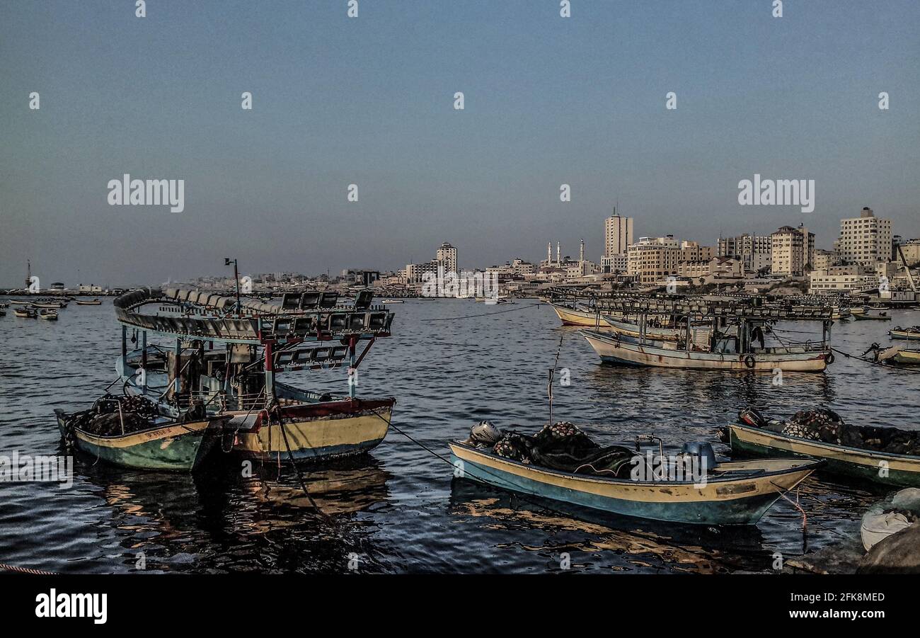 Boats of Palestinian fishermen dock at the Gaza port during sunset. In ...