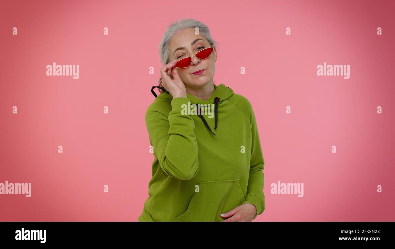 Happy playful elderly stylish granny woman in sunglasses blinking eye ...