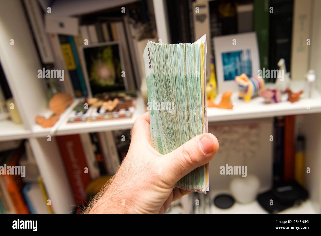 Male hand holding large stack of thousands of euros Stock Photo - Alamy