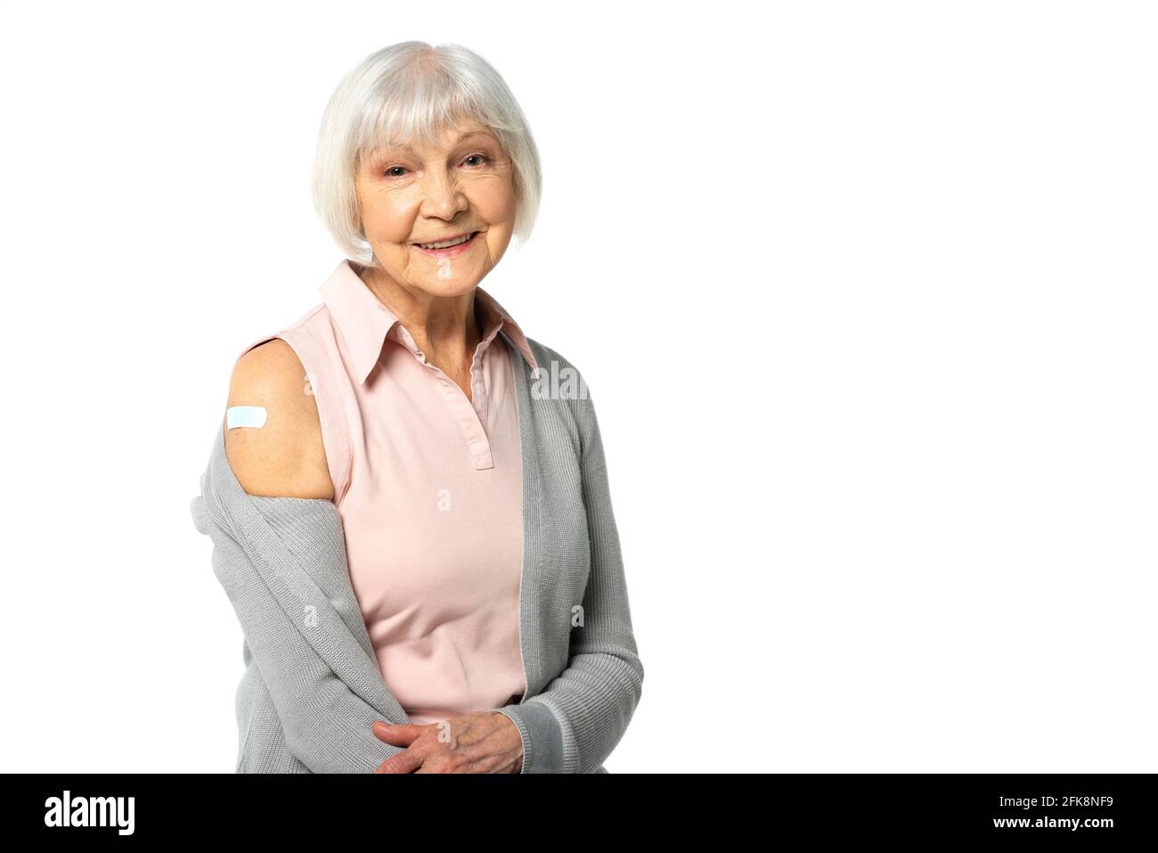 Positive elderly woman with adhesive plaster on arm looking at camera ...