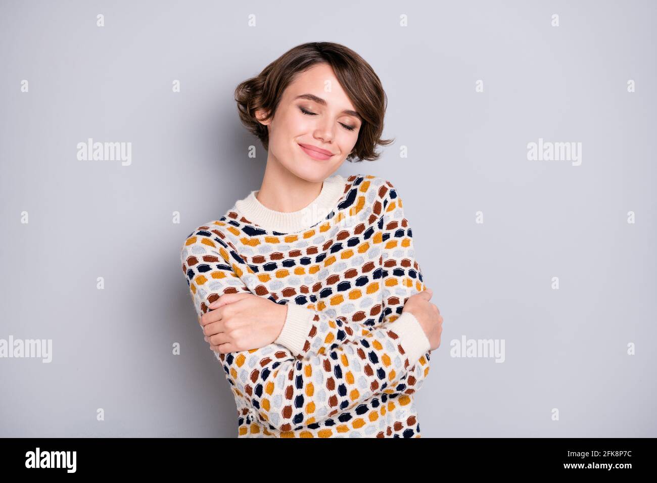 Portrait of lovely dreamy girl hugging herself enjoying silence ...
