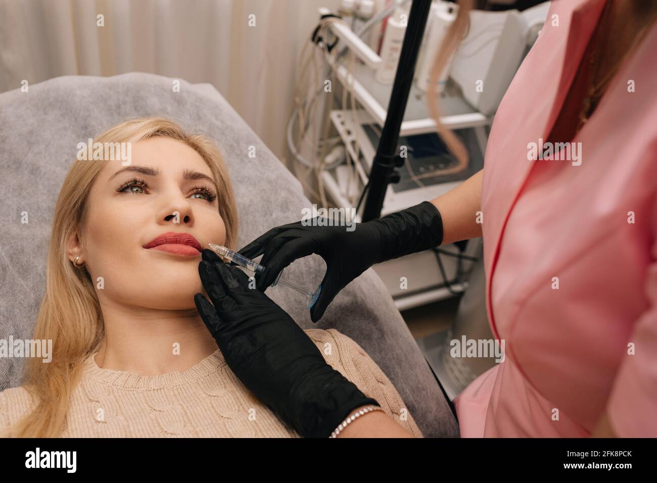 The female client lies on procedure at beautician in spa. Lip ...