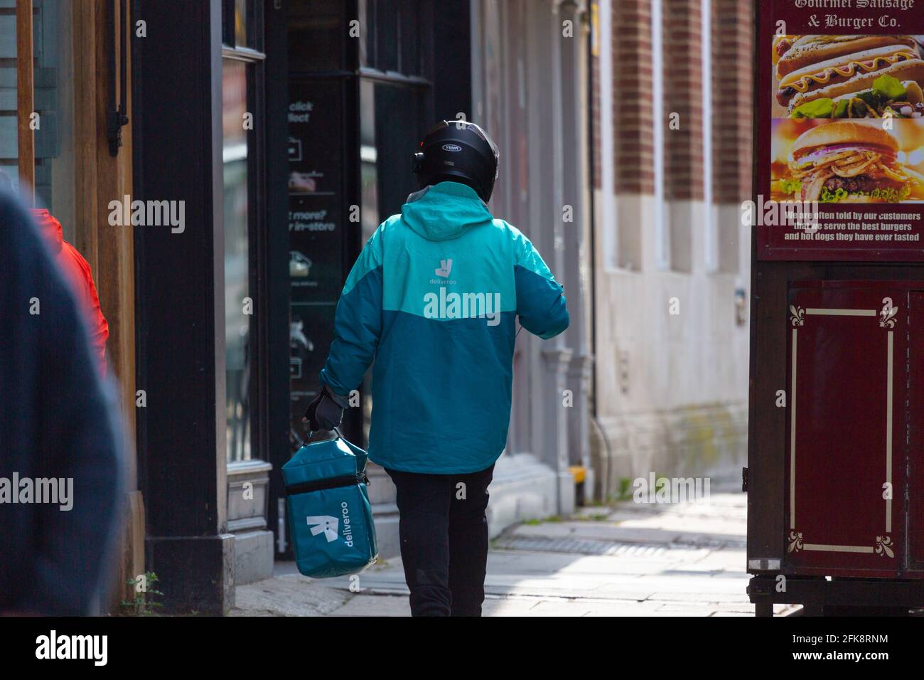 Deliveroo delivery wearing helmet walking, Canterbury high street, kent ...
