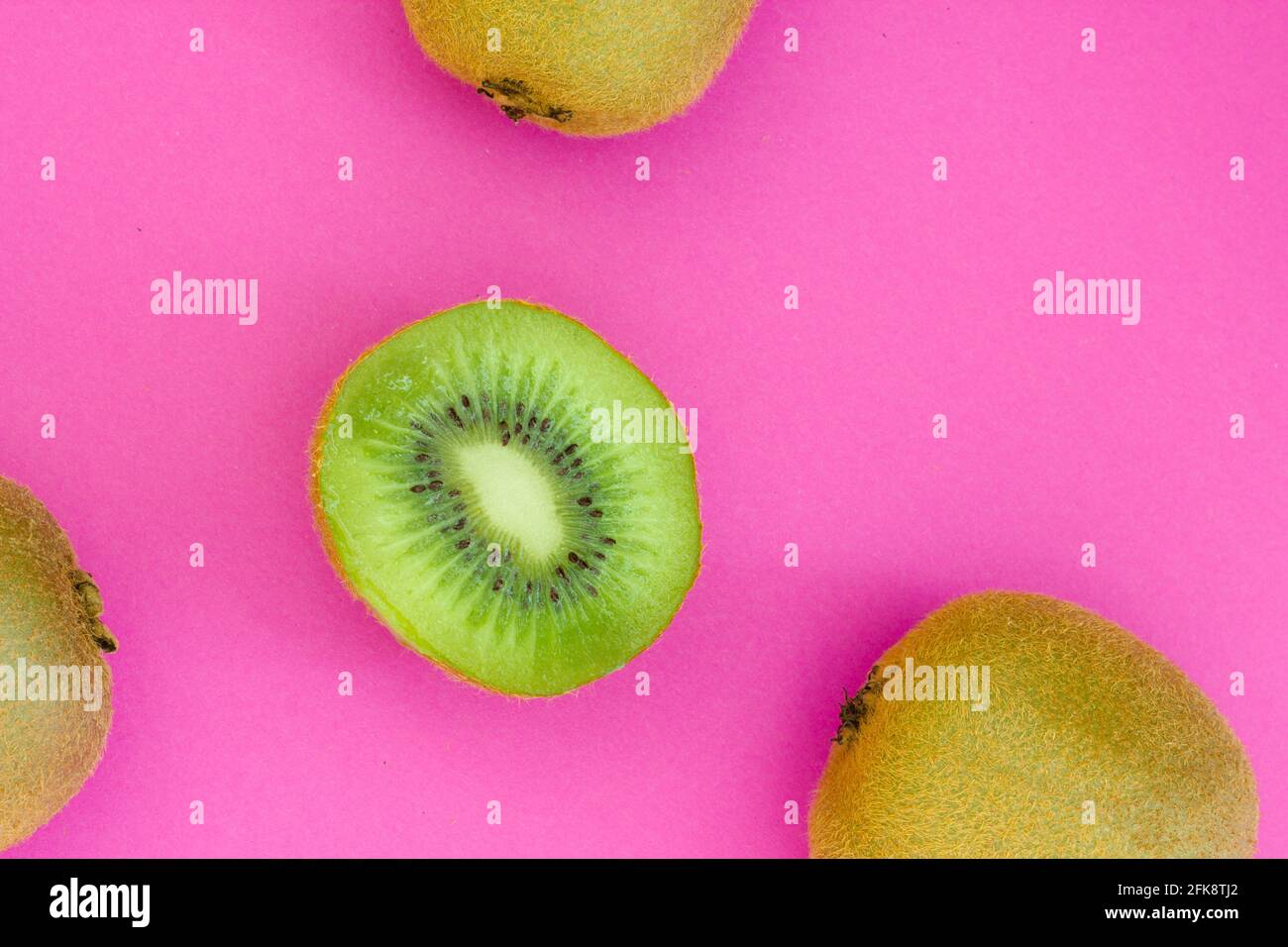 Cut kiwi fruits on pink background; colorful summer background; kiwi ...