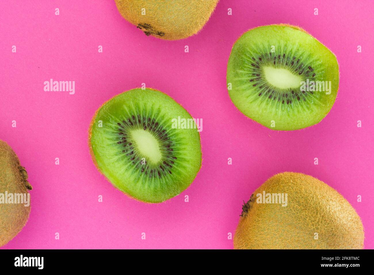 Cut kiwi fruits on pink background; colorful summer background; kiwi ...