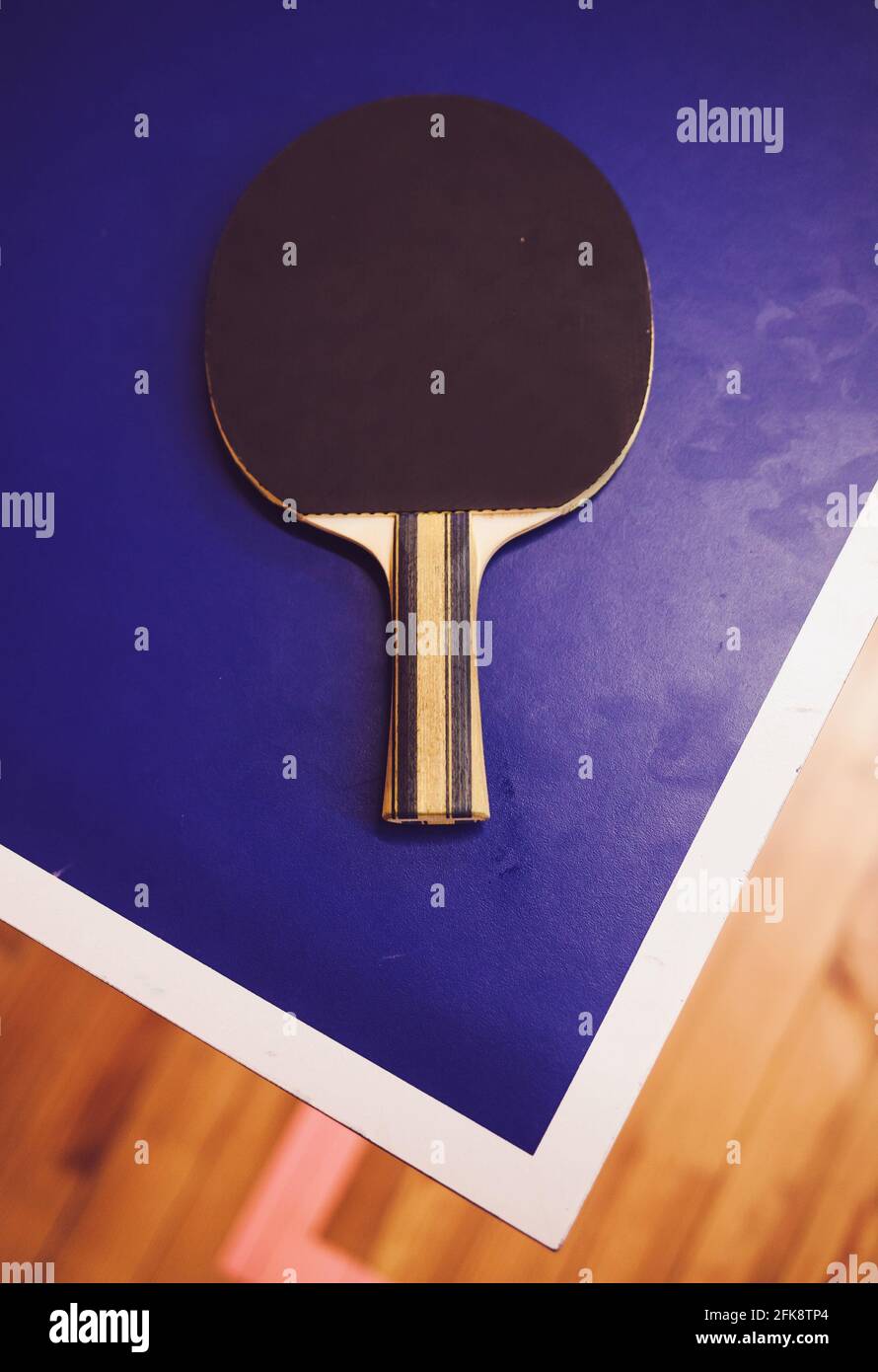 tennis racket on the corner of the blue table. the game of ping pong ...