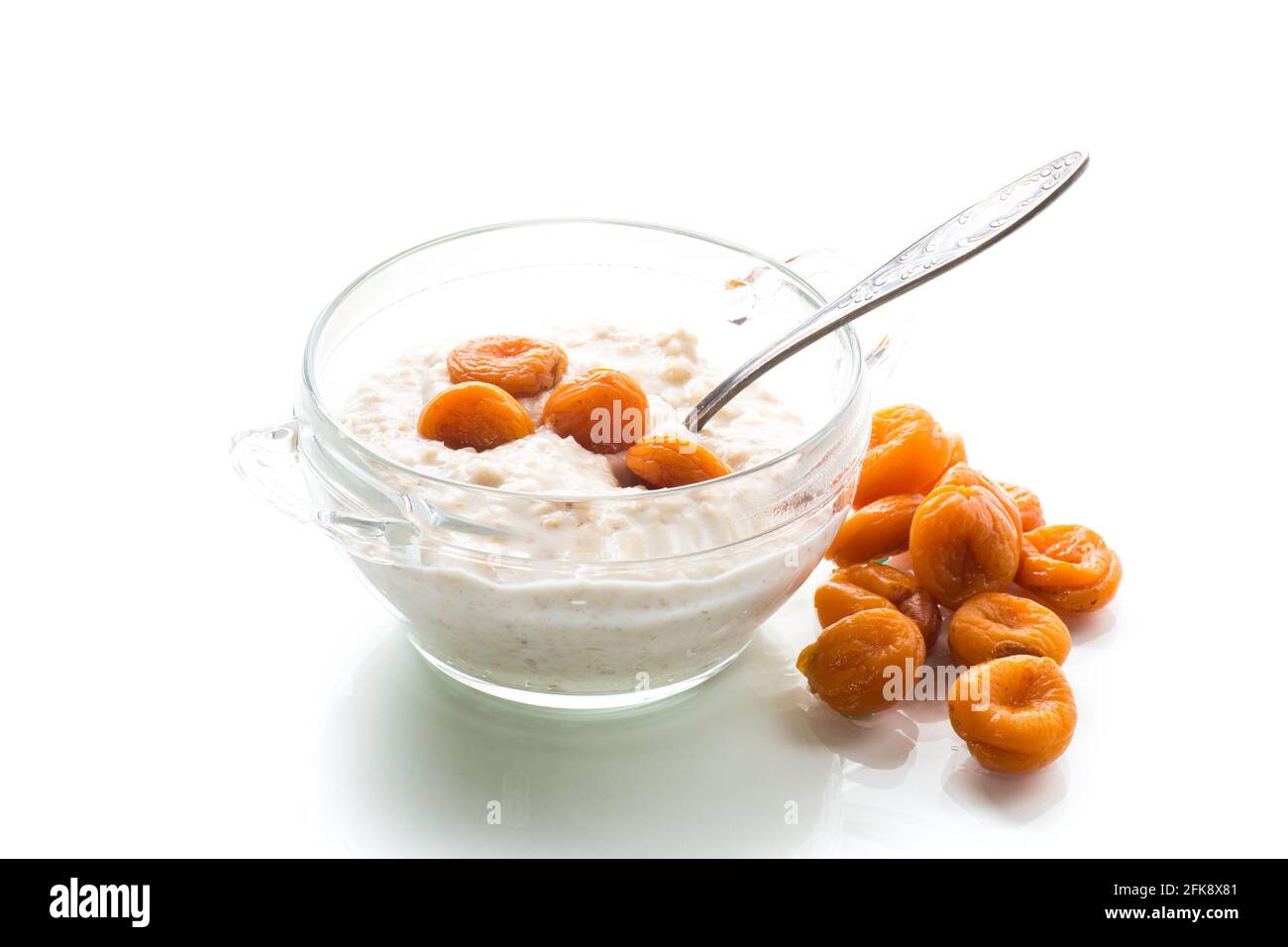 cooked boiled sweet oatmeal with dried apricots in a bowl isolated on ...