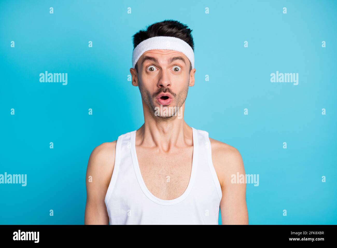 Photo of amazed shocked sportive man wear white headband singlet ...